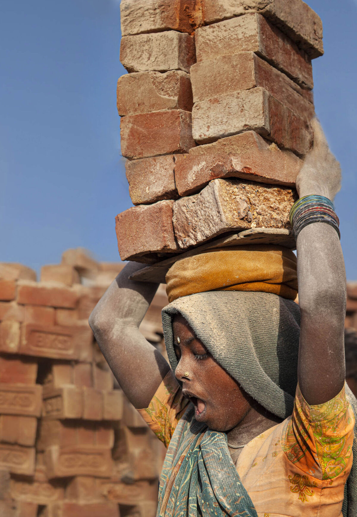 Girl Carrying Bricks - India - Lisa Kristine